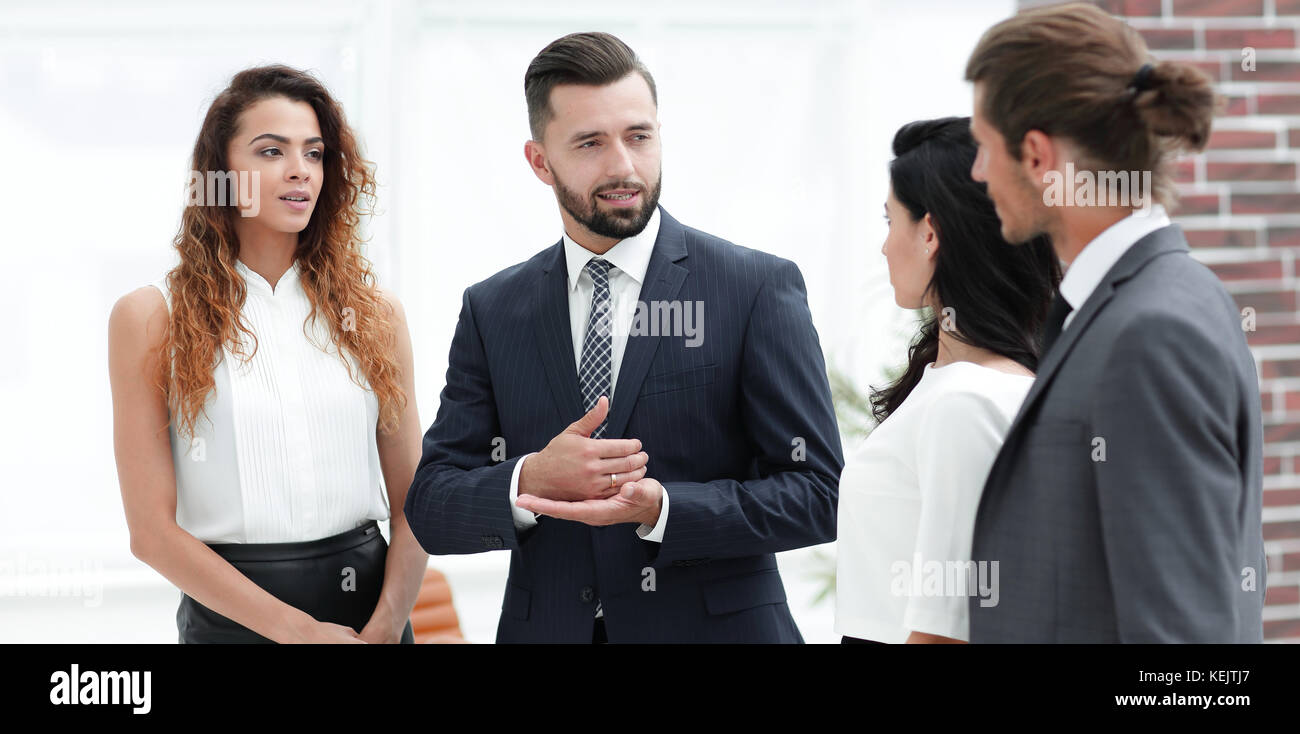 smiling business team talking, standing in office Stock Photo - Alamy