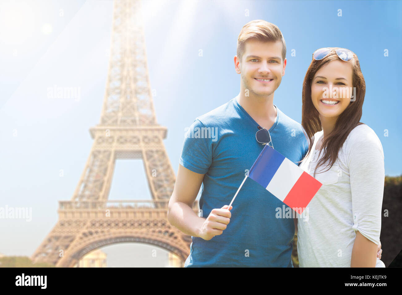 Happy Couple Holding French Flag In Front Of Eiffel Tower Stock Photo ...
