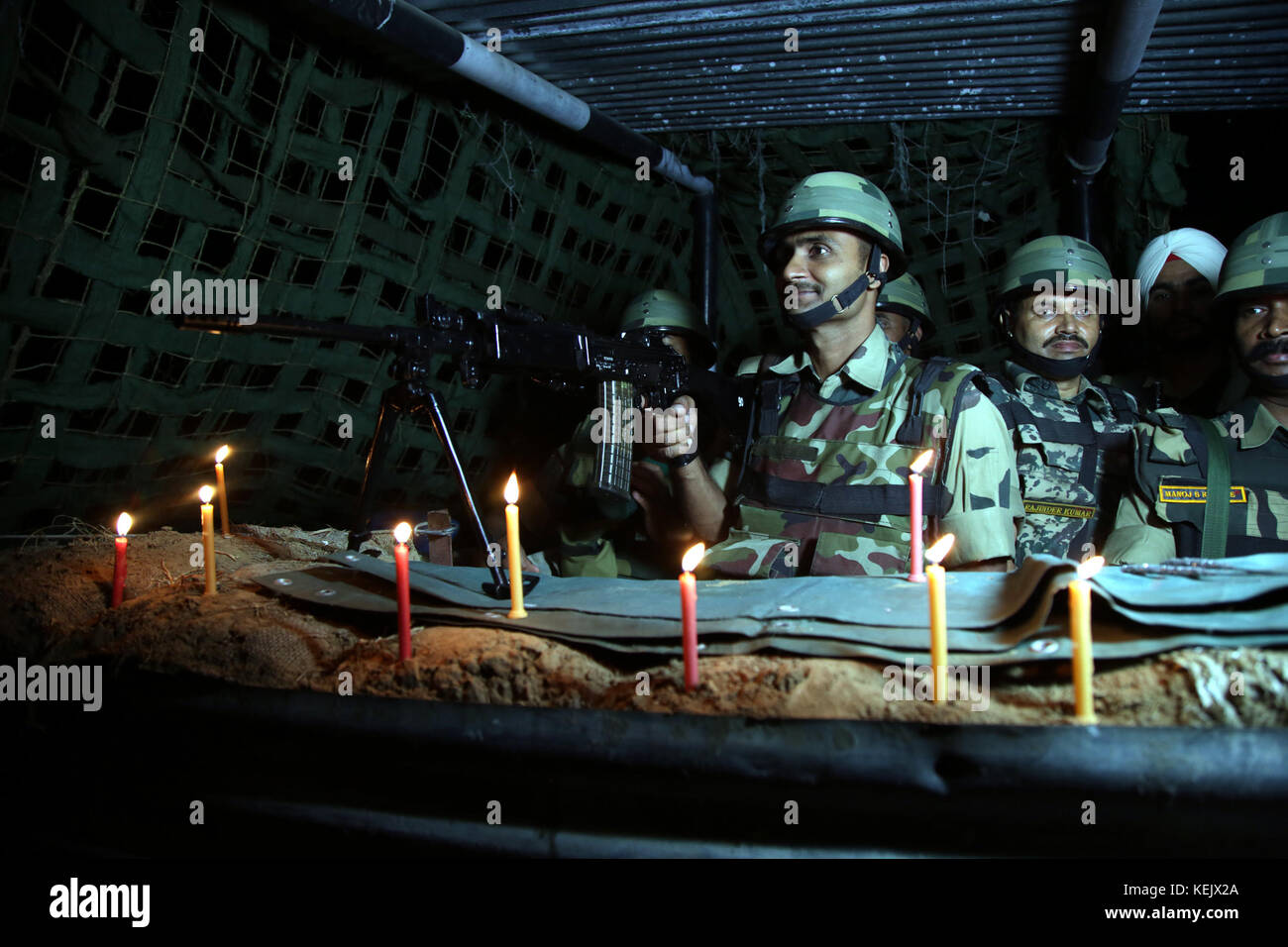 An Indian Border Security Force (BSF) soldier lights candles in a ...