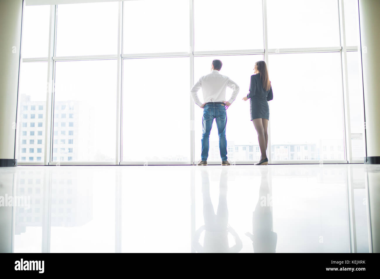 Office staff is discussing something by the window Stock Photo - Alamy
