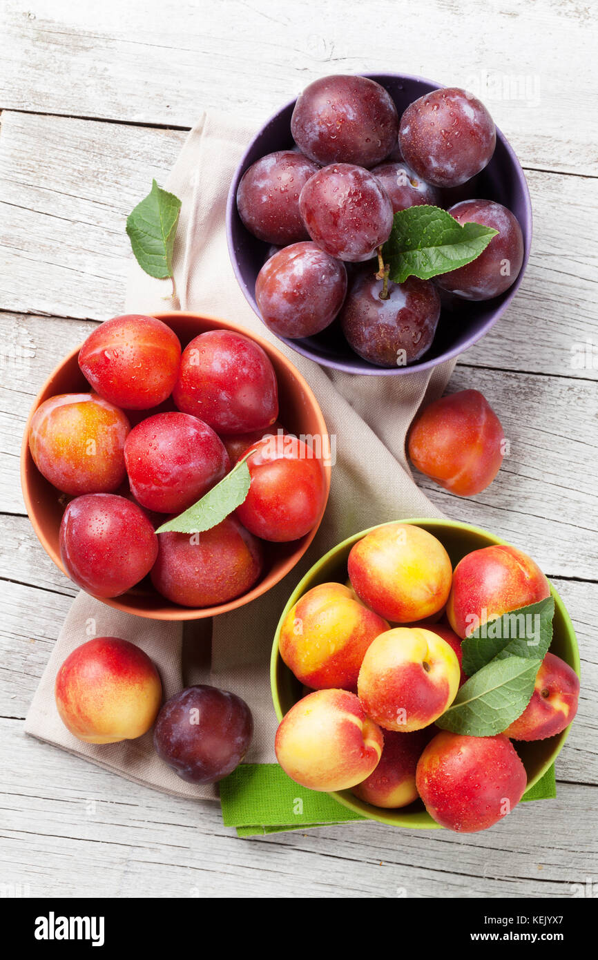 Fresh ripe peaches and plums on wooden table. Top view Stock Photo - Alamy