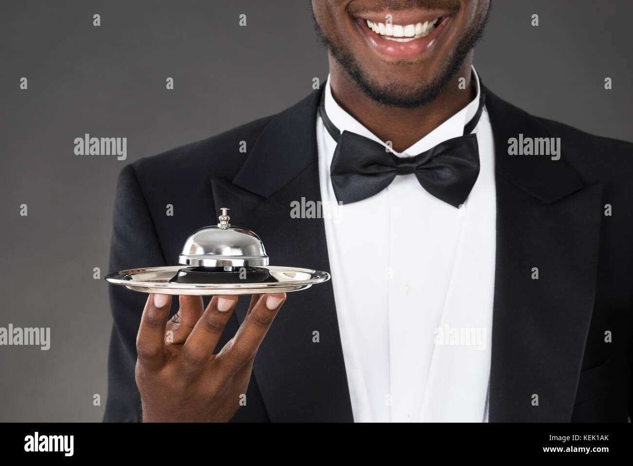 Portrait Of Happy African Waiter Holding Service Bell Stock Photo - Alamy