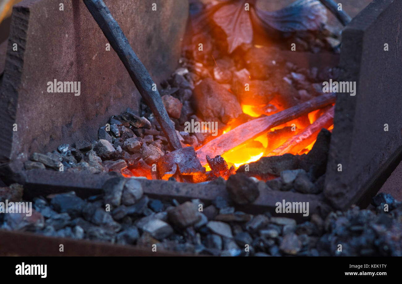blacksmith furnace with burning coals, tools, and glowing hot metal ...