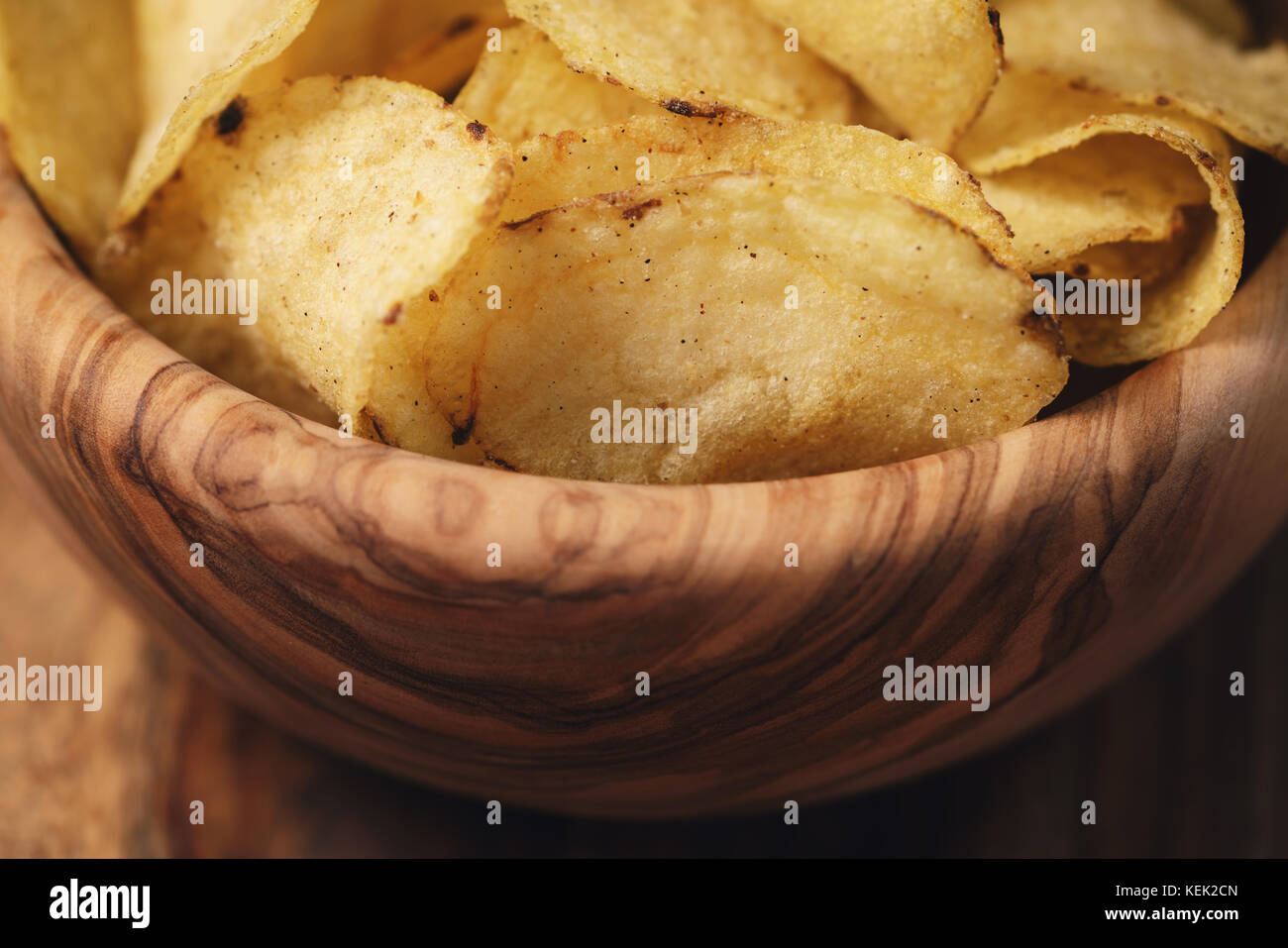closeup potato chips with herbs in wood bowl on rustic table, simple ...