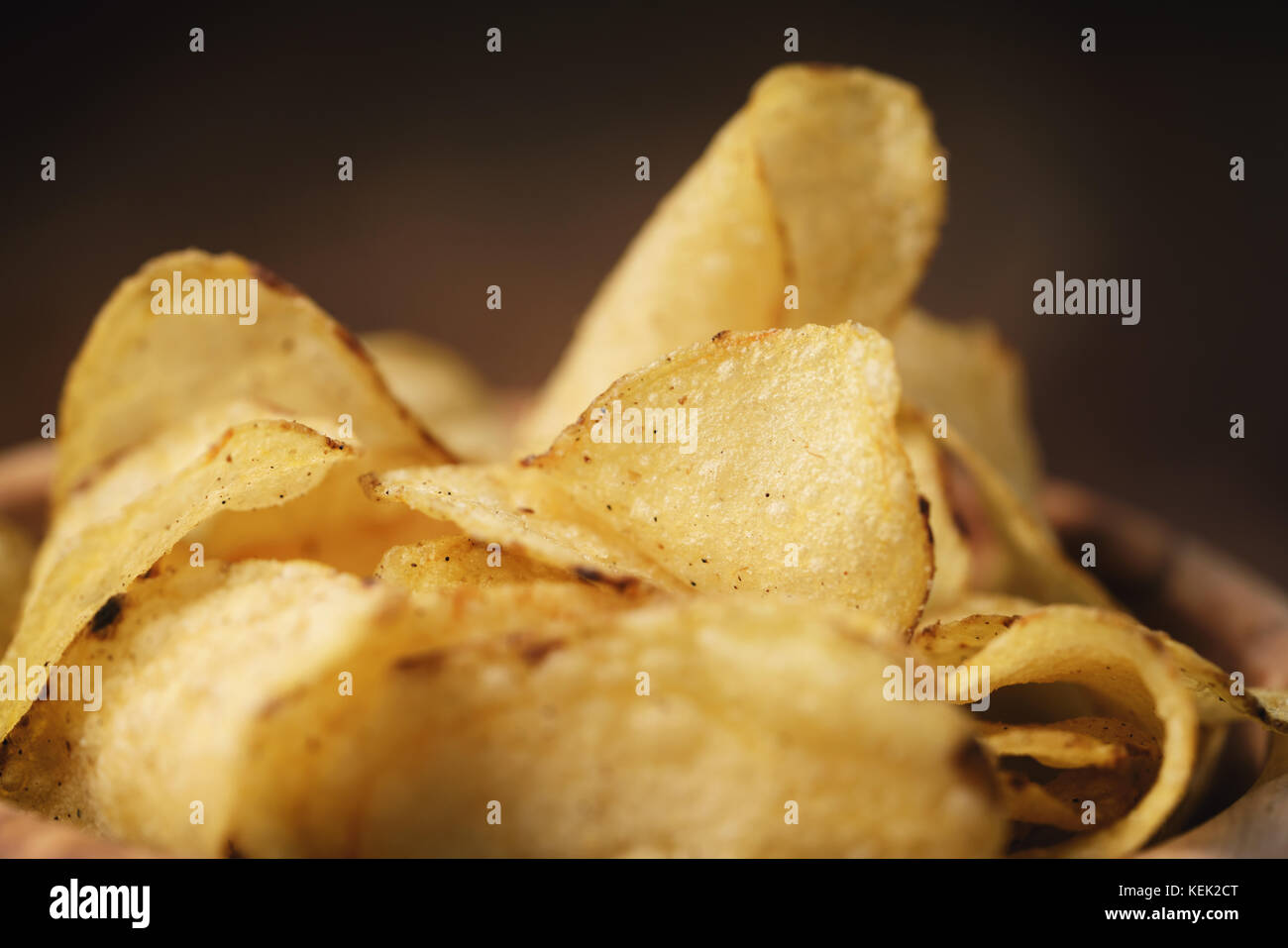 closeup potato chips with herbs in wood bowl on rustic table, simple ...