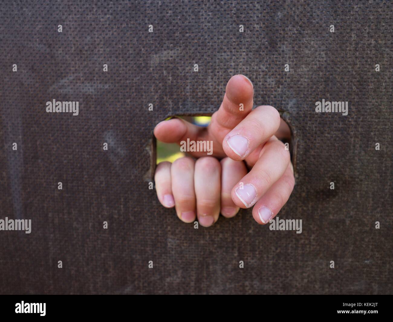 Children hand holds a hole on the wooden climbing wall. Short fingers ...