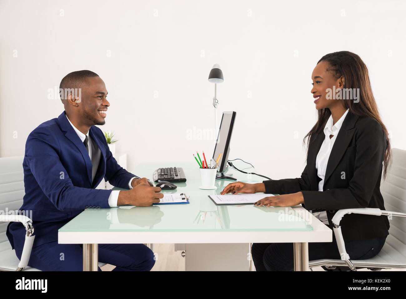 Male Manager Interviewing A Young Female Applicant In Office Stock ...