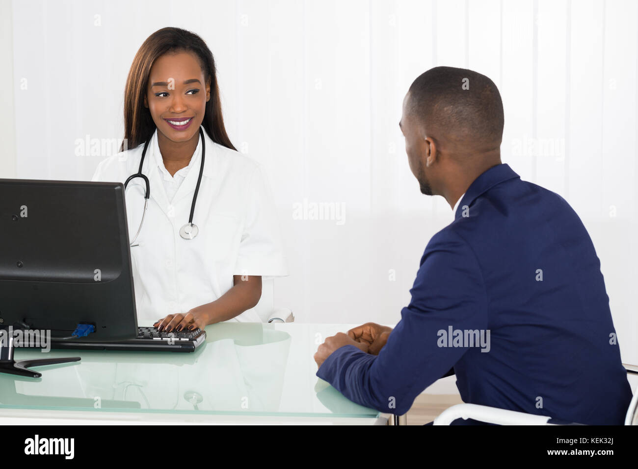 African American Doctor And Patient Discussing On Computer At ...