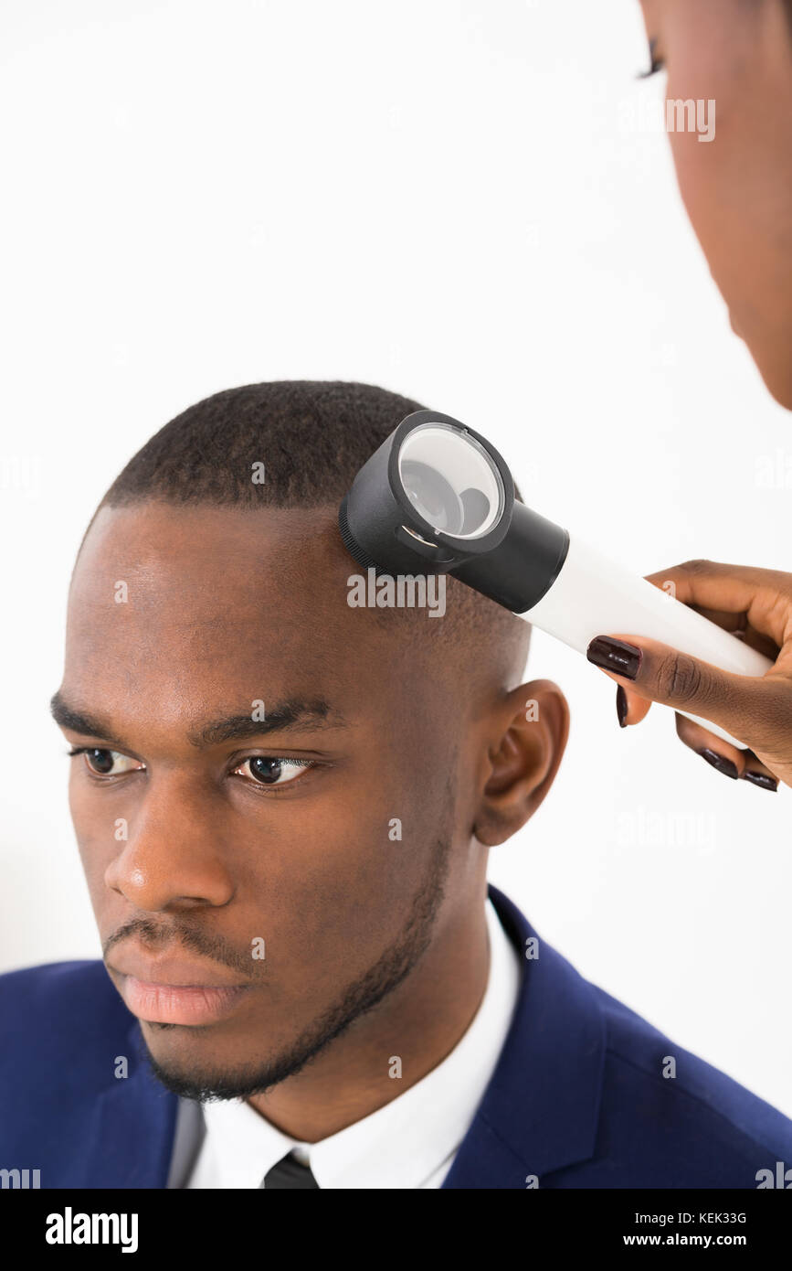 Dermatologist Checking Mole On African American Man In Clinic Stock ...