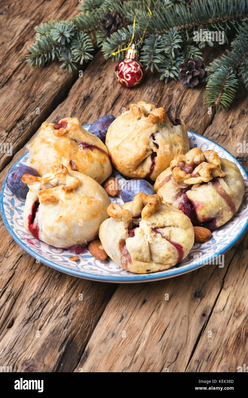 Christmas sweet plum buns on the background of Christmas decorations ...