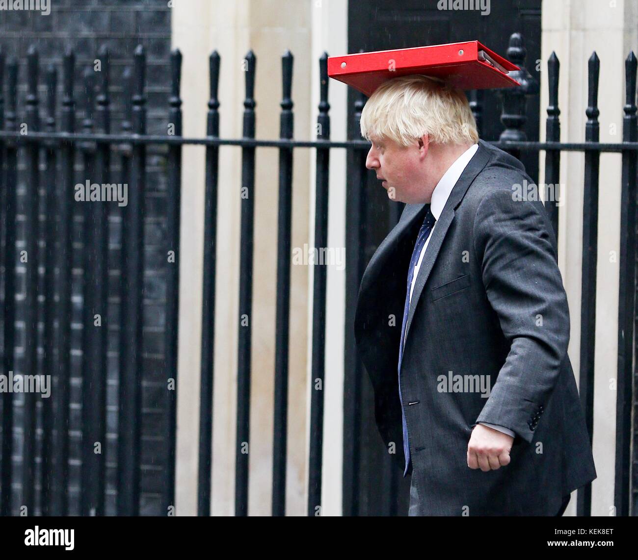 Boris Johnson in Downing Street walks out into the rain using his ...