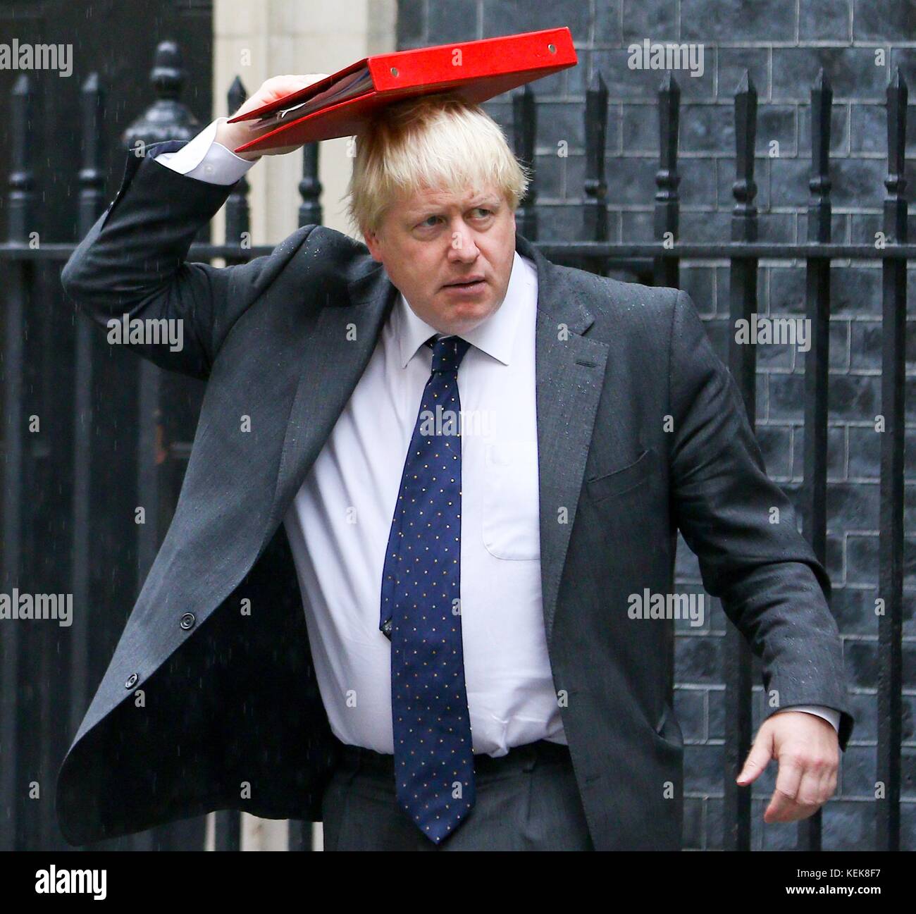 Boris Johnson in Downing Street walks out into the rain using his ...