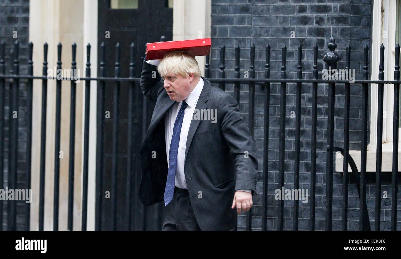 Boris Johnson in Downing Street walks out into the rain using his ...