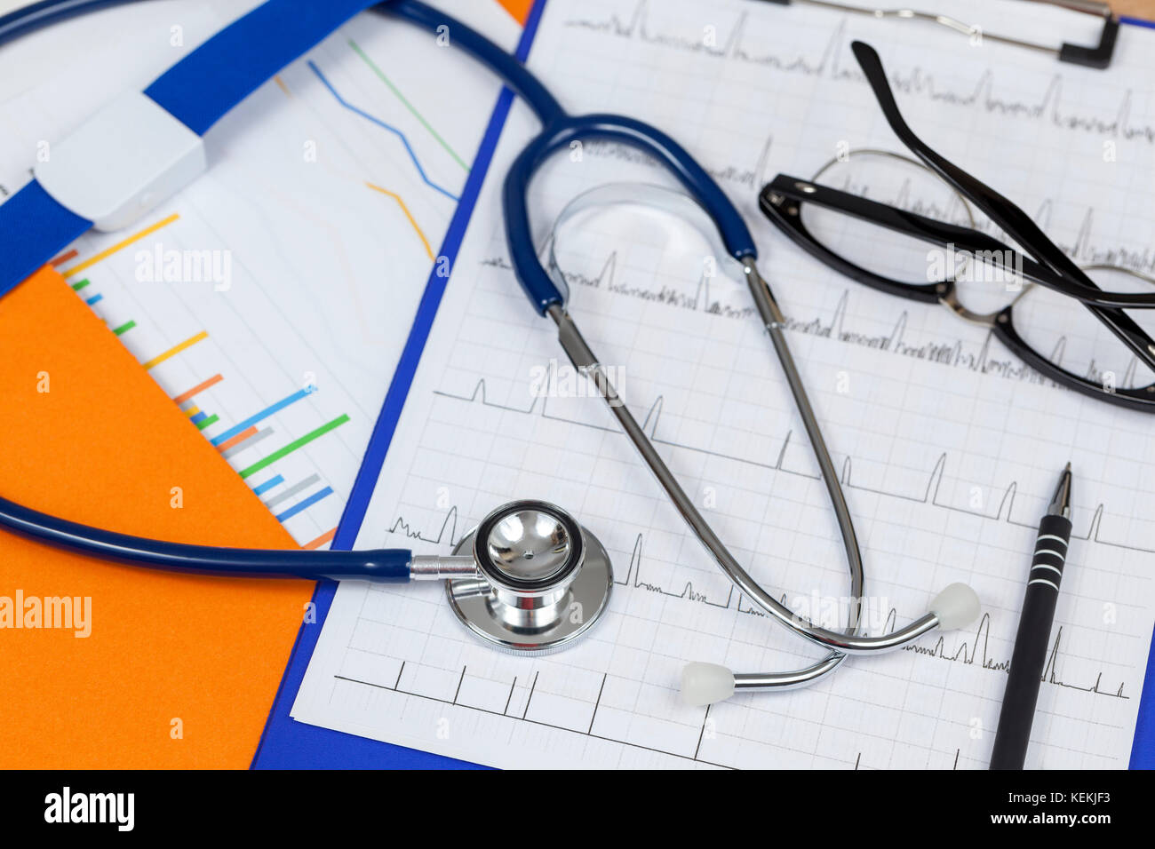 Stethoscope and spectacles laying on a doctors clipboard with a ...