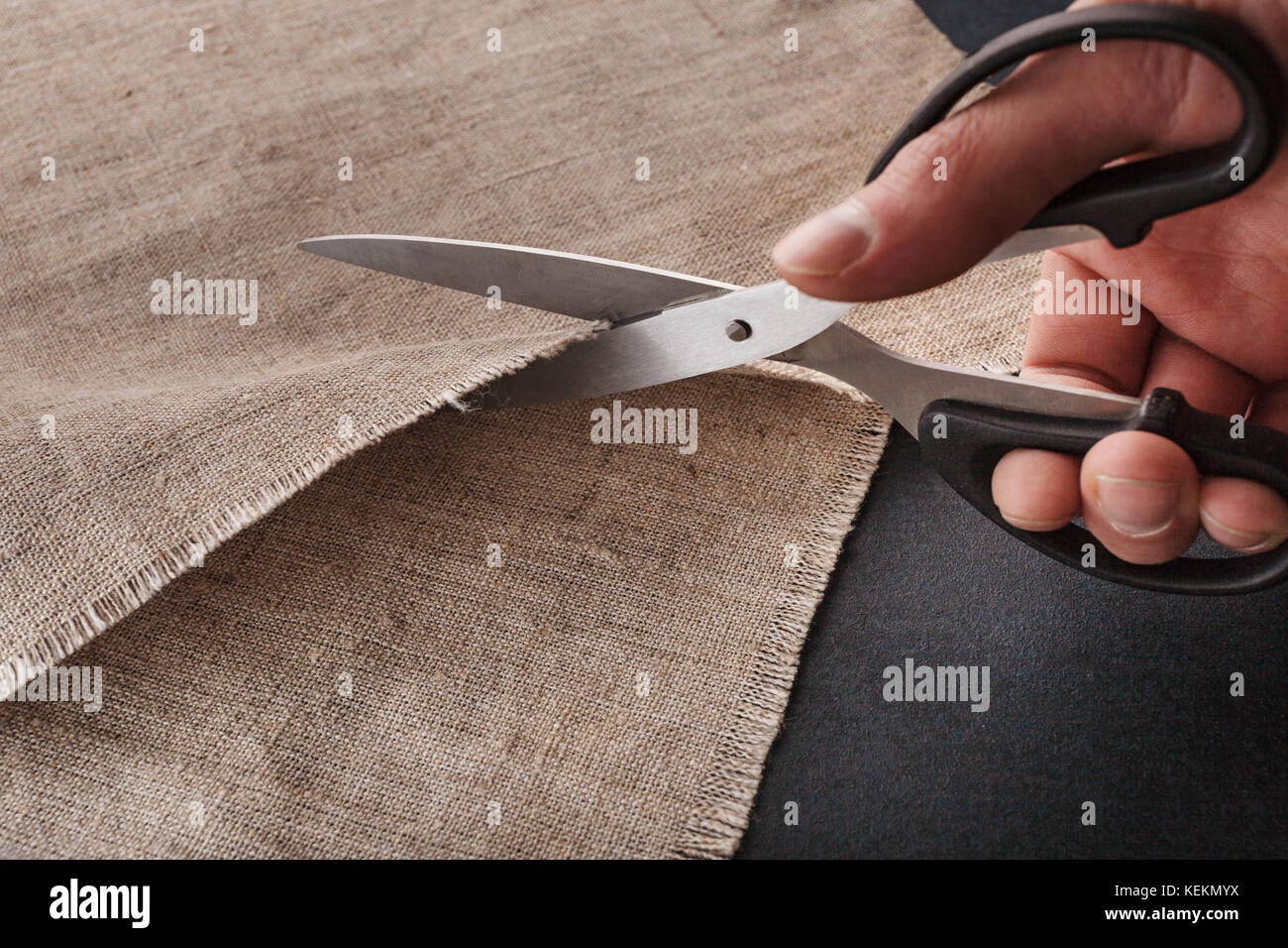 A man's hand cuts linen cloth with tailor's scissors Stock Photo - Alamy