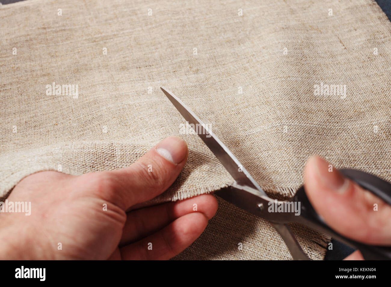 A man's hand cuts linen cloth with tailor's scissors Stock Photo - Alamy