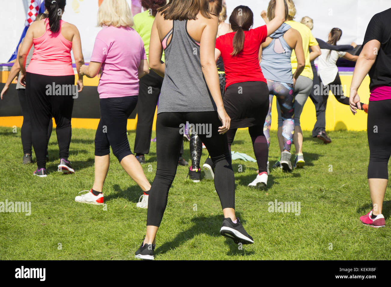 Group of young girls exercising fitness with dancing in the city park ...