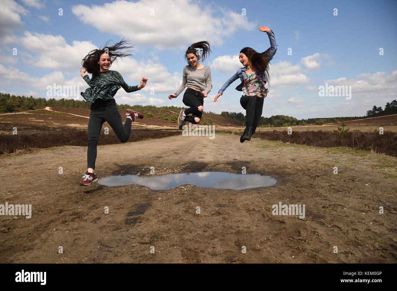 Three girls jumping on Hankley Common Stock Photo - Alamy