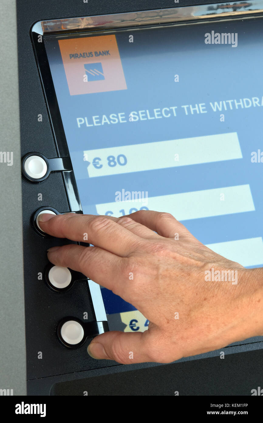 a woman using a cashpoint machine or a hole in the wall automatic ...