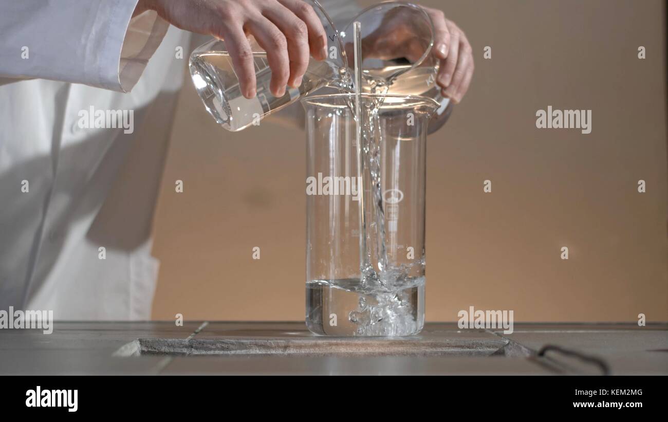 Male researcher carrying out scientific research in a lab. Flasks with ...