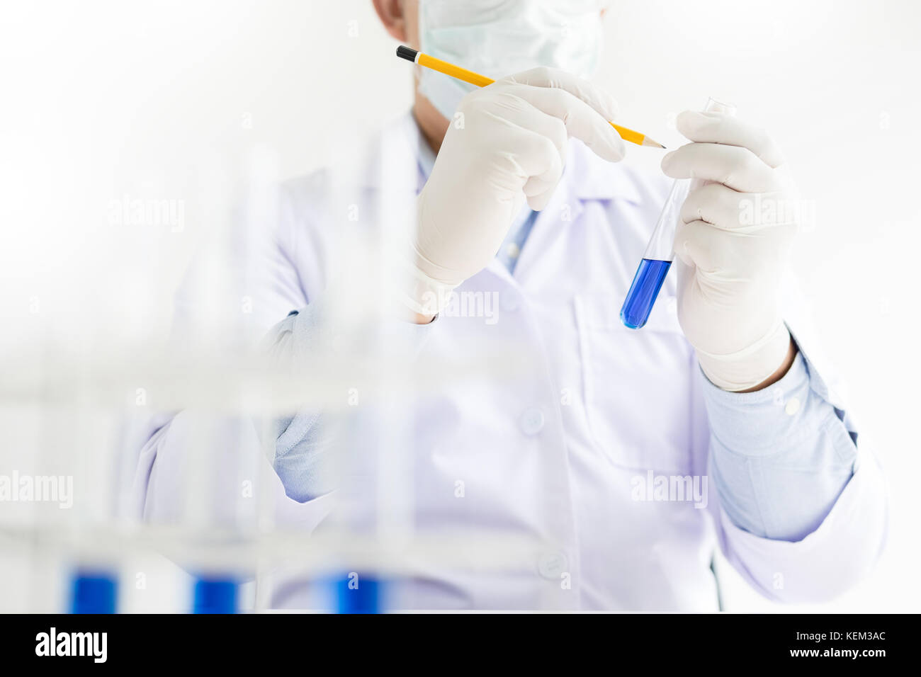 Scientist holding pencil for label on test tube reagent for analysis ...