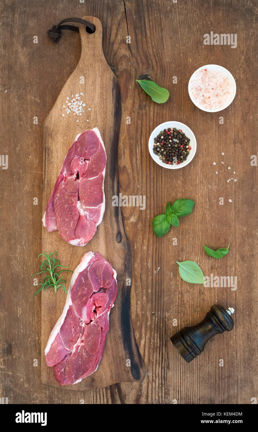 Raw fresh meat lamb entrecote and seasonings on cutting board over ...