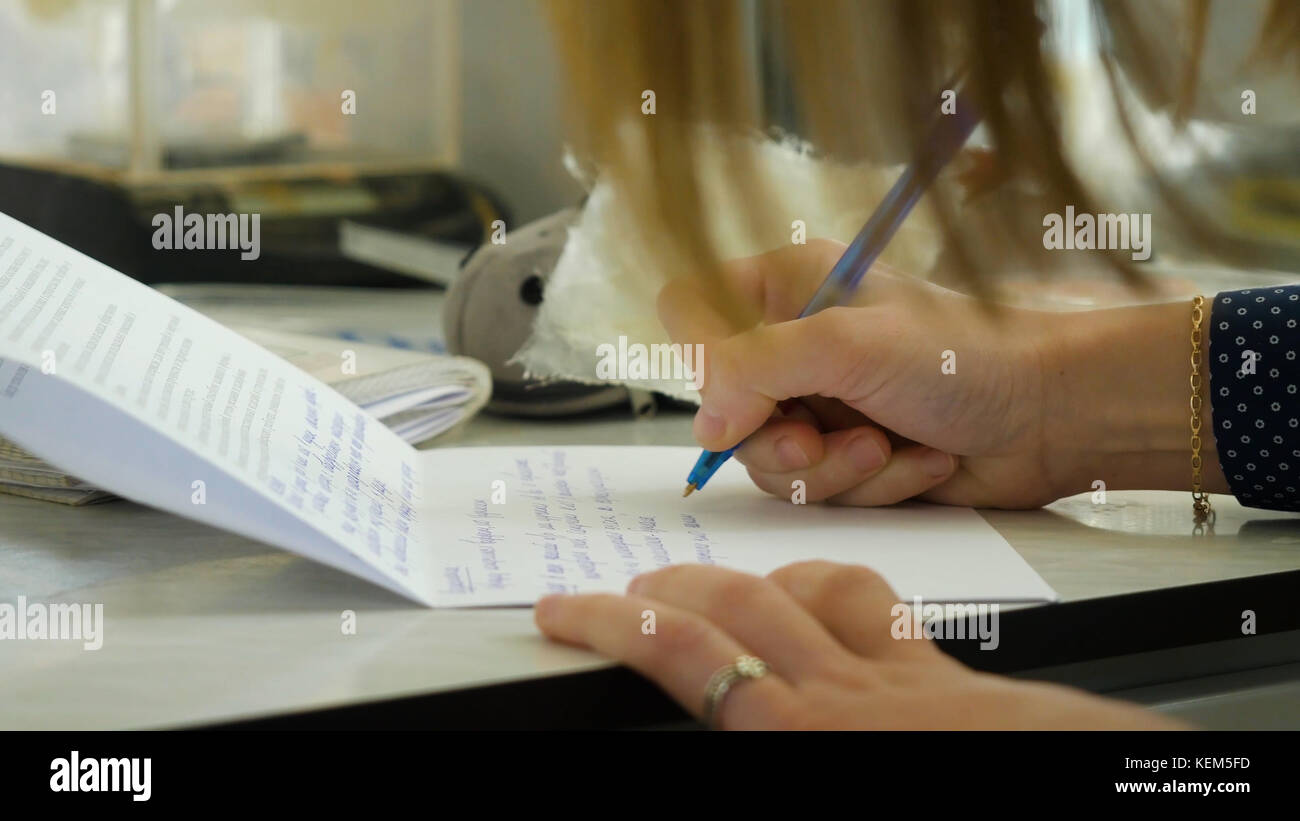 Closeup of a female hand writing on an blank notebook with a pen. Close ...