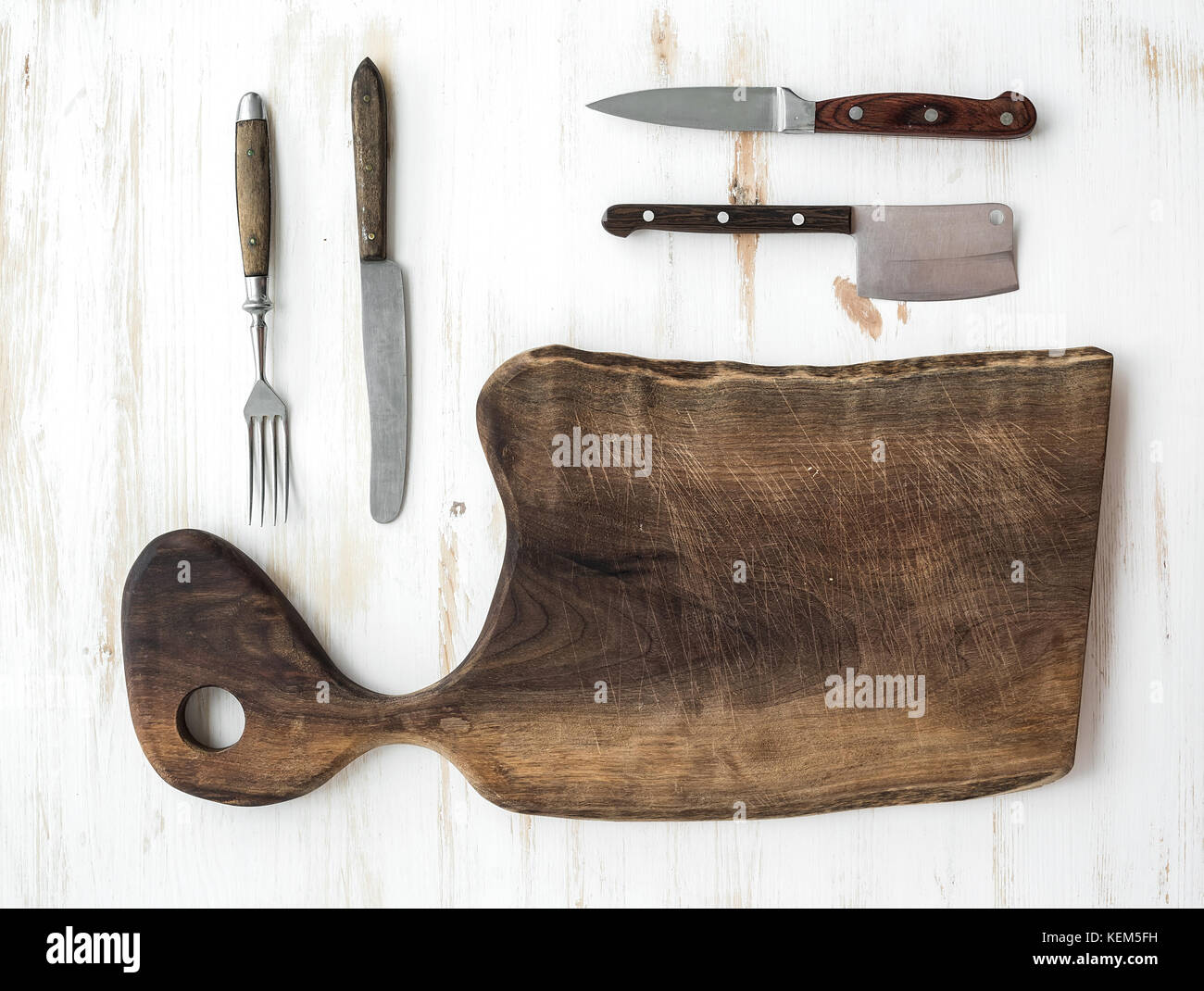 Kitchen-ware set. Old rustic chopping board made of walnut wood, knives ...