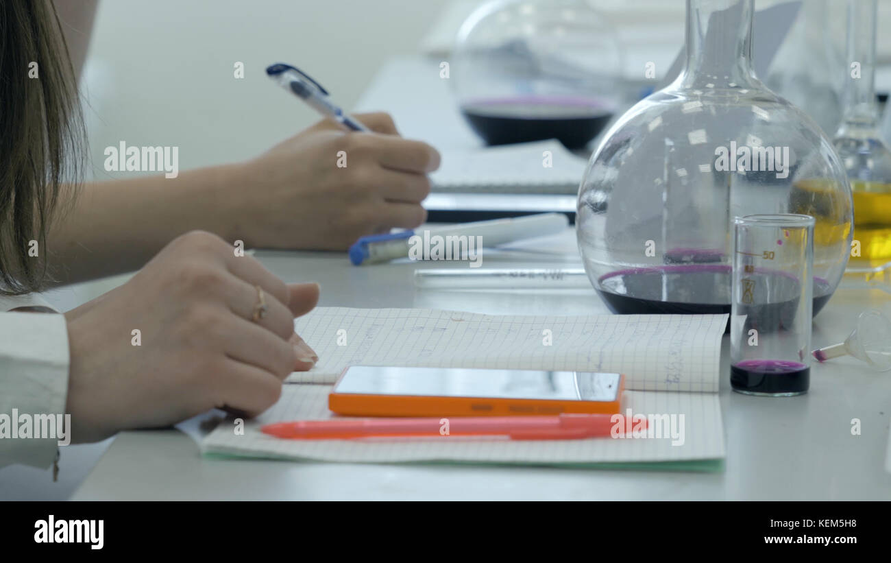 Students at work in the laboratory of chemistry take notes in a ...