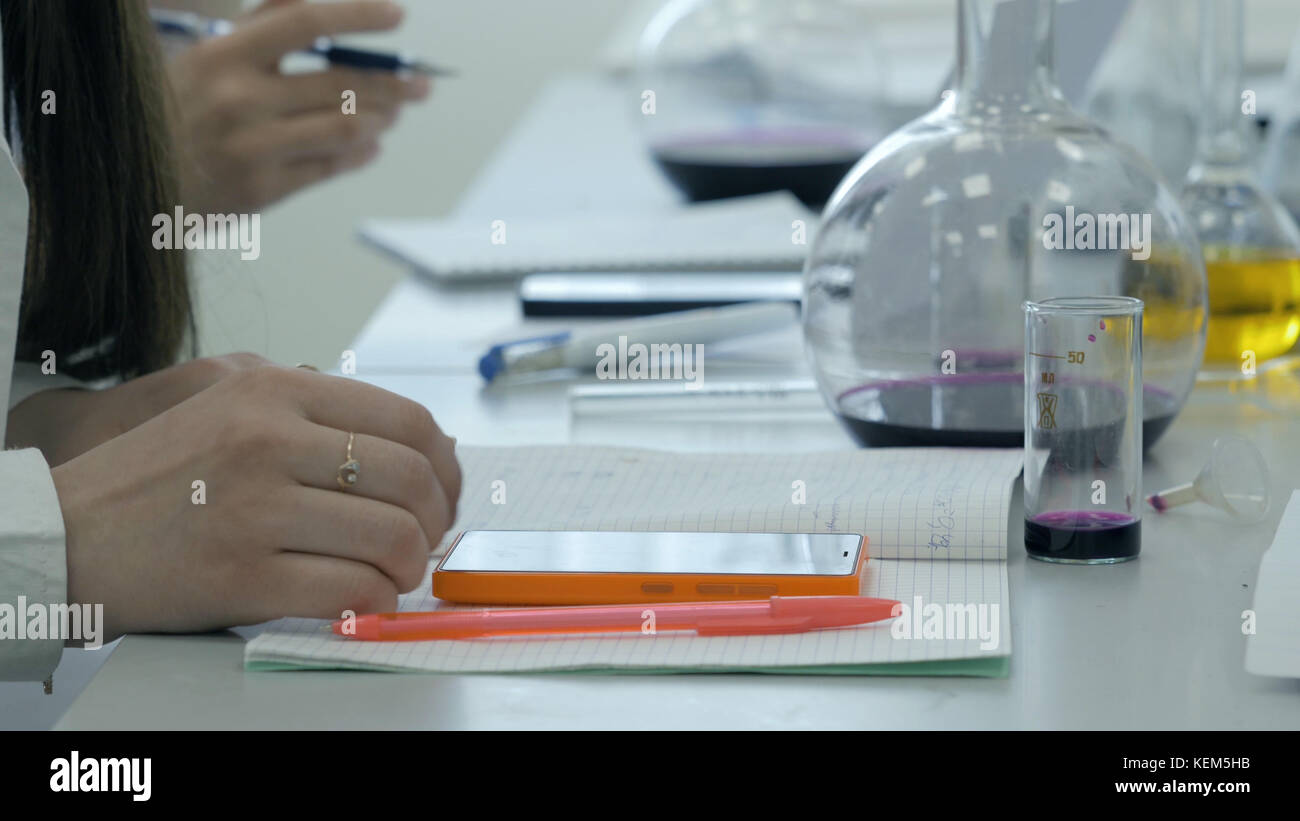 Students at work in the laboratory of chemistry take notes in a ...