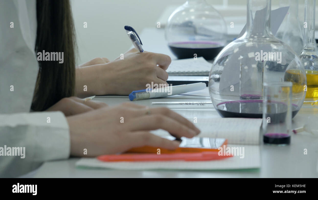 Students at work in the laboratory of chemistry take notes in a ...