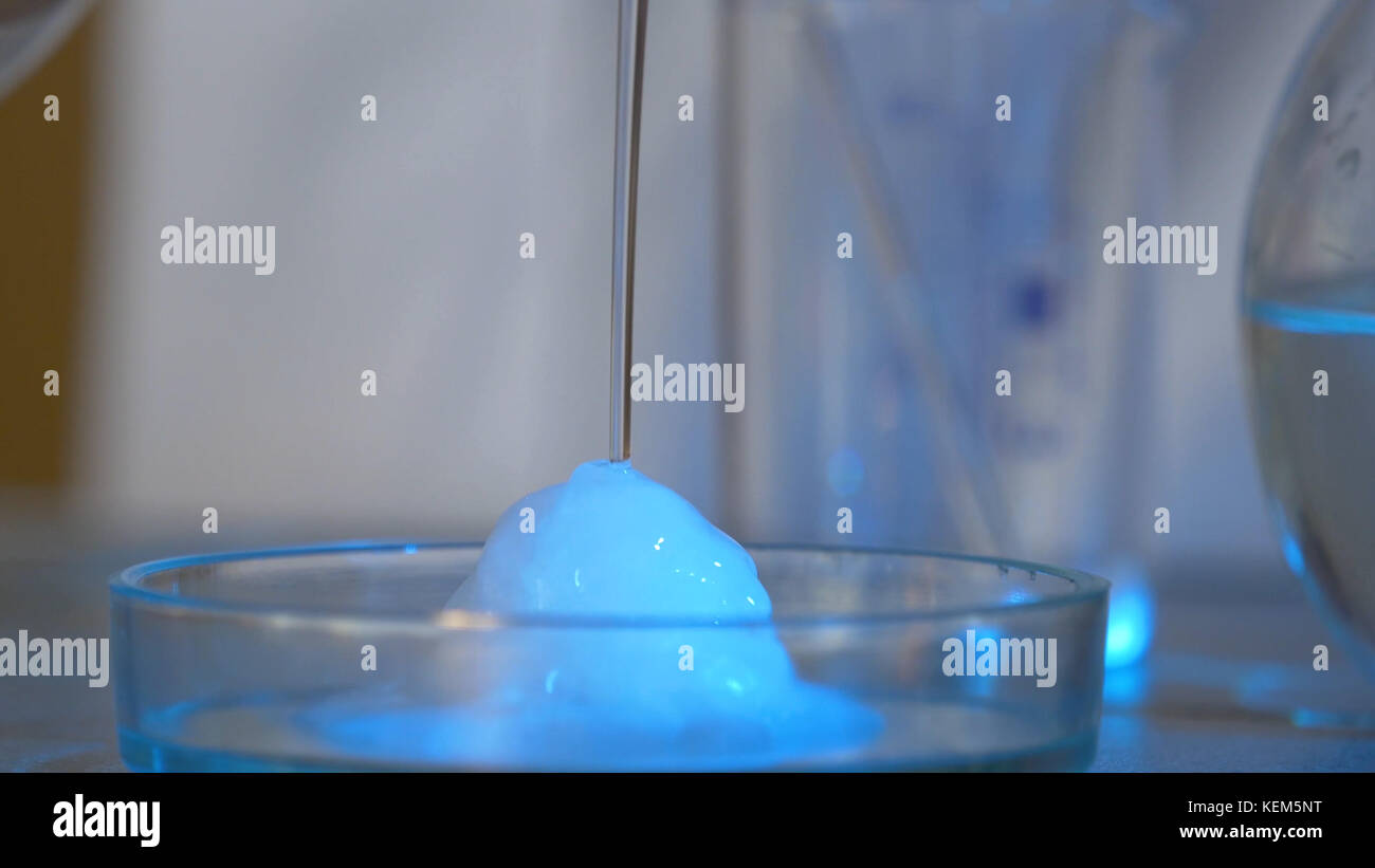 Chemical experiments. The liquid pours from the glass onto the black ...