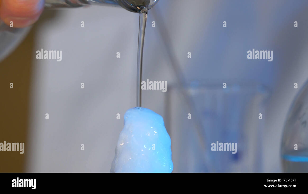 Chemical experiments. The liquid pours from the glass onto the black ...