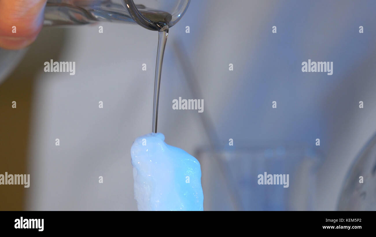 Chemical experiments. The liquid pours from the glass onto the black ...