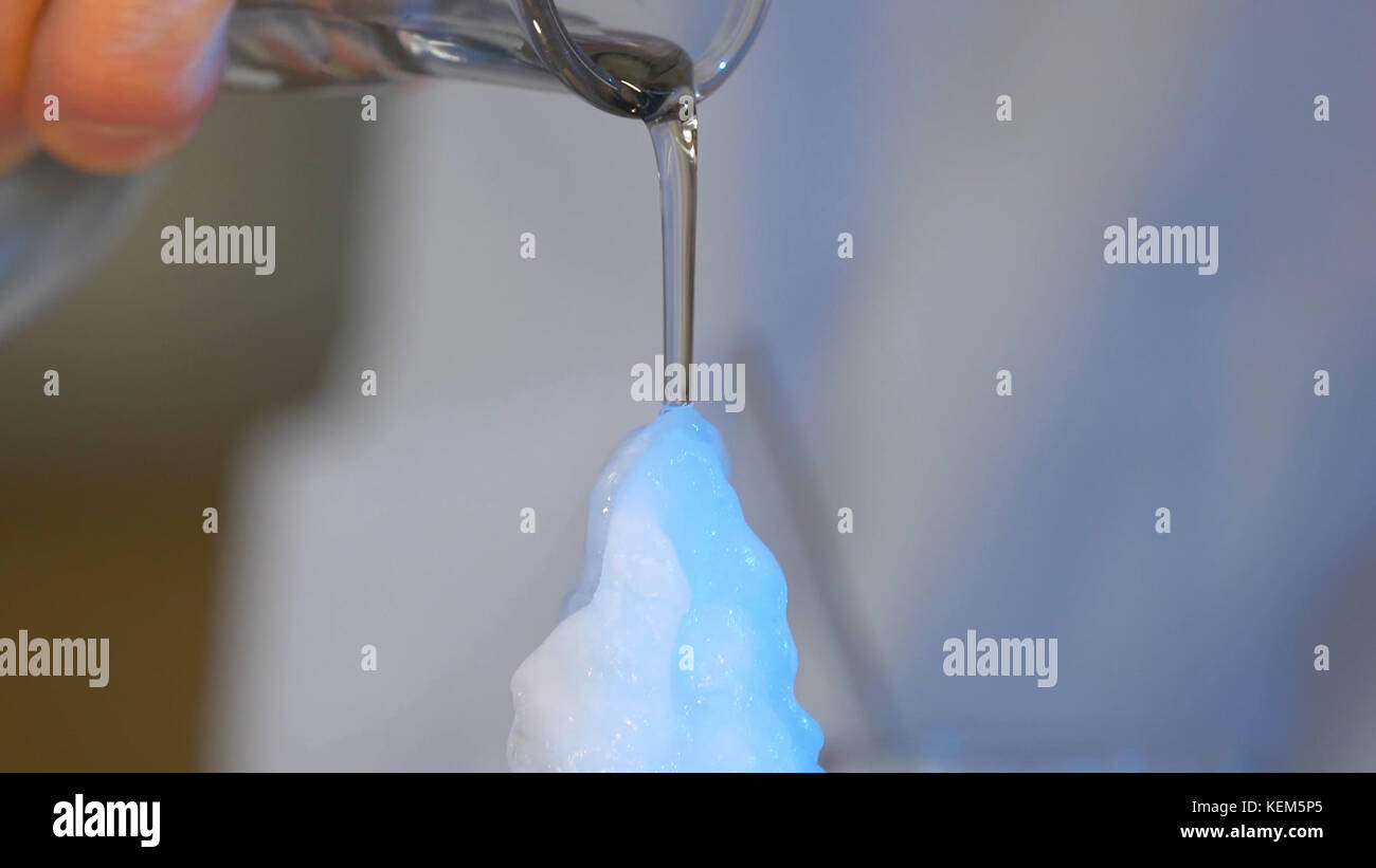 Chemical experiments. The liquid pours from the glass onto the black ...