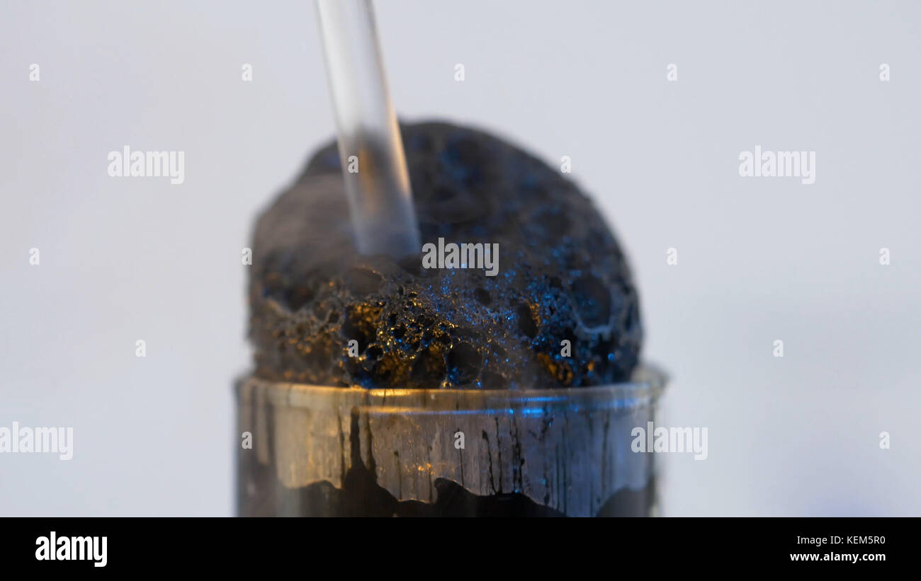 Black mixture out of the flask. glass flasks on black background Stock ...