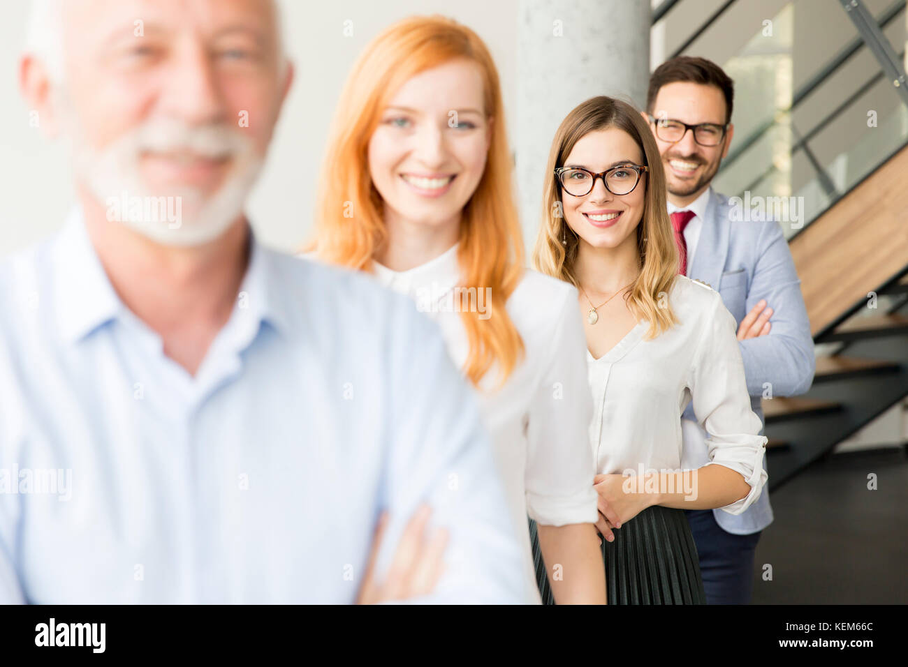 Young business people with senior colleague standing in the office ...
