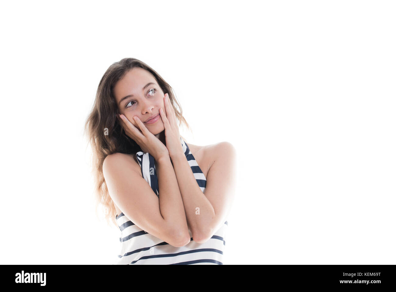 Young pretty woman looking up, hands over face with smiling deciding ...