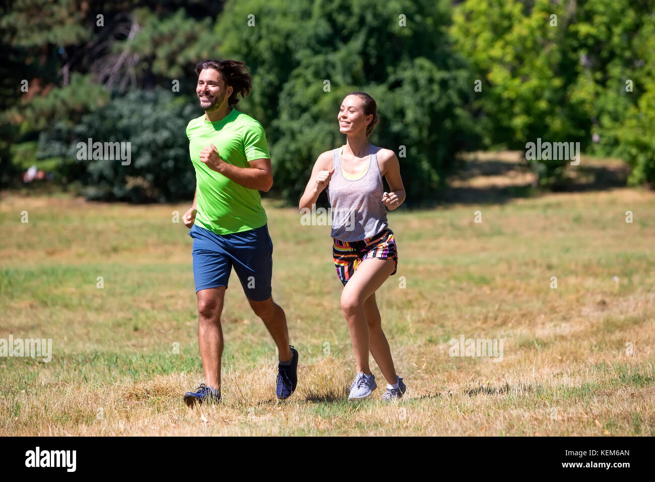 Healthy, fit and sportive couple running in park at summer morning ...