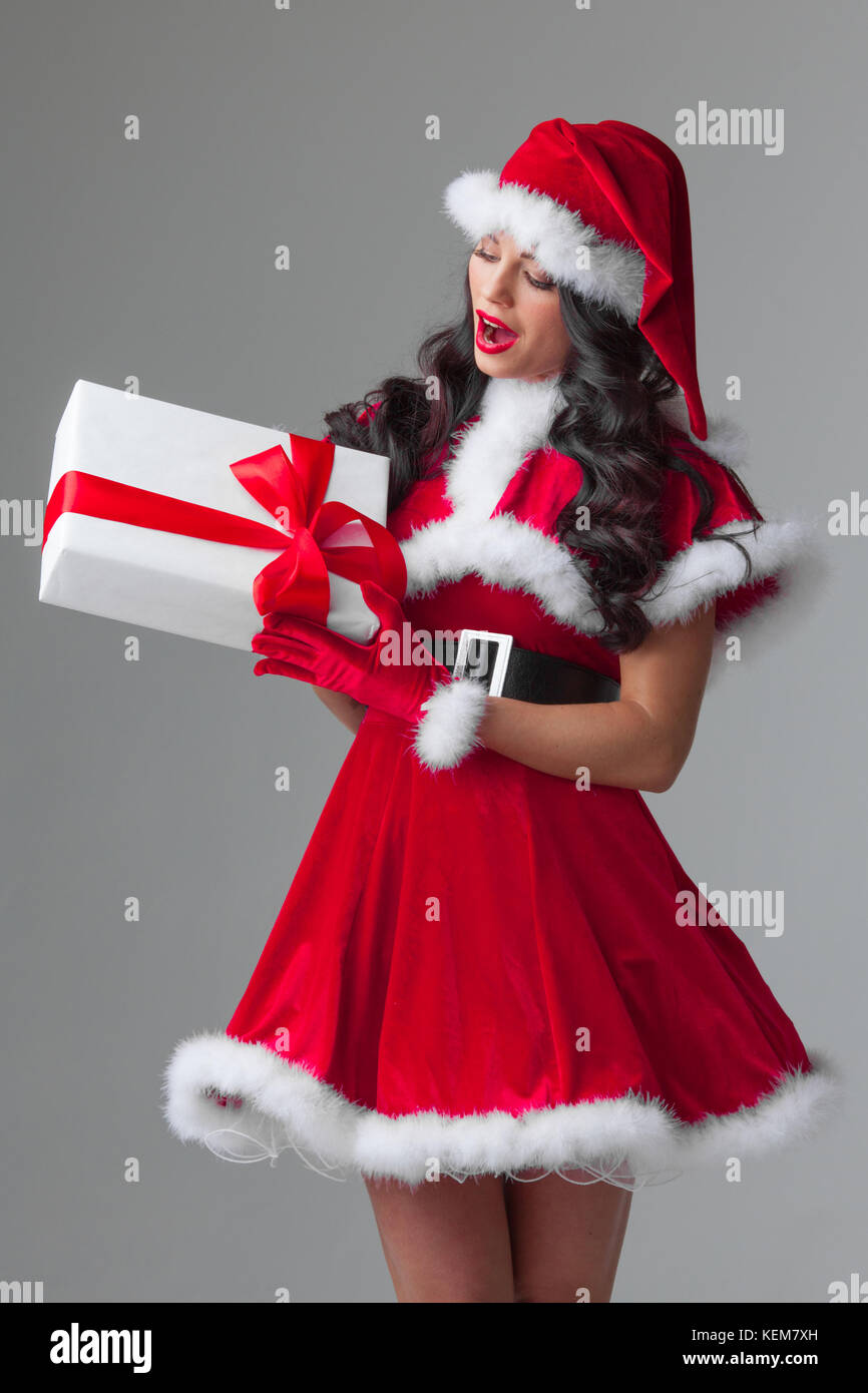 Woman in red Santa Claus outfit holding christmas gift box Stock Photo ...