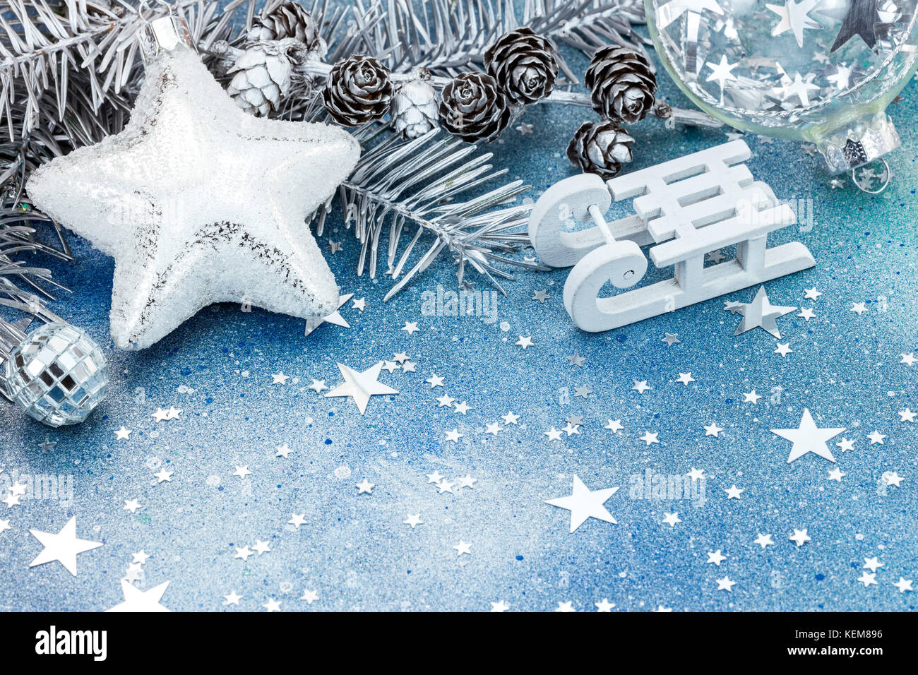 glass star, white sledge, balls and fir tree branches with cones on ...