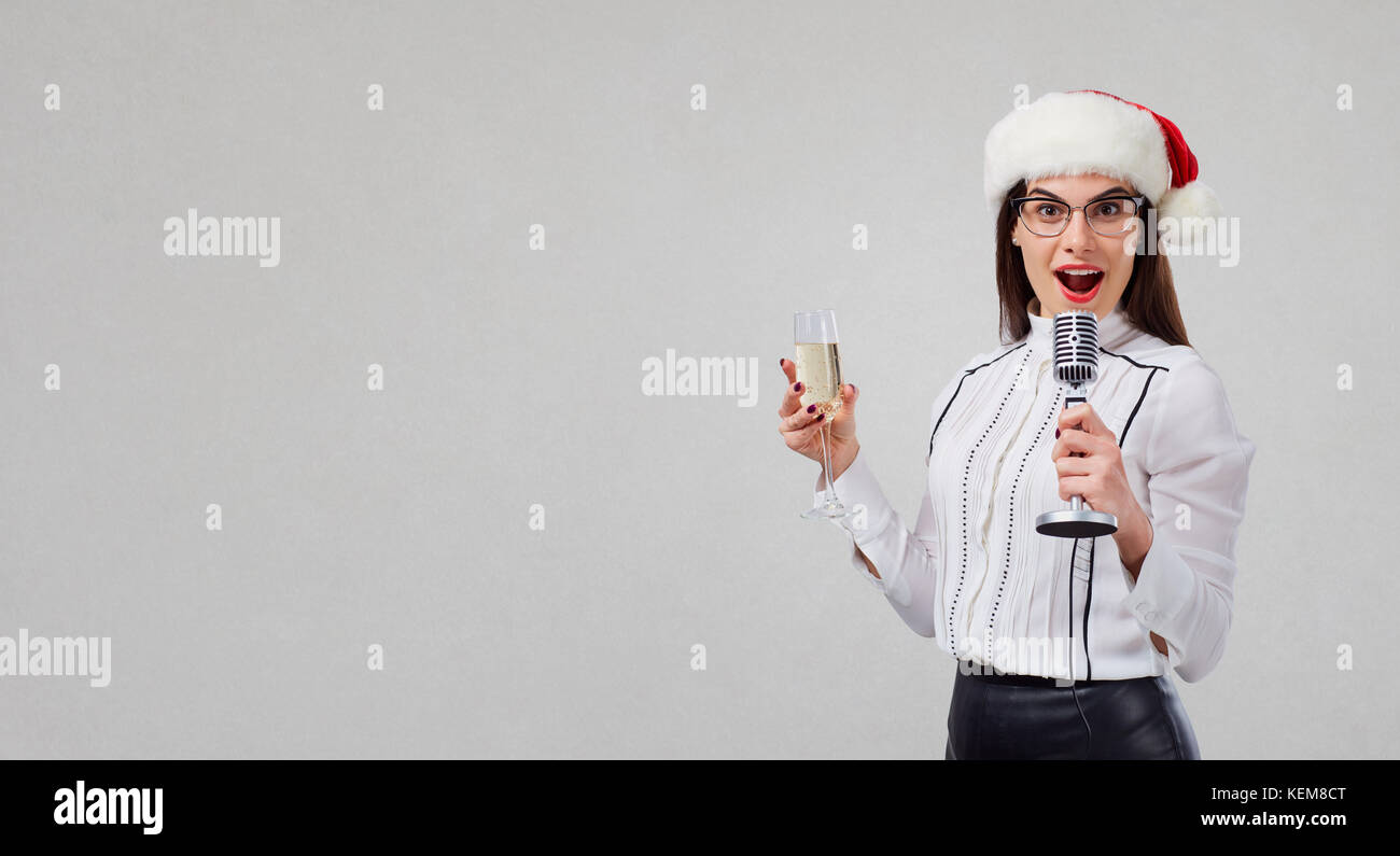 A woman in a Santa Claus hat sings a karaoke into the microphone Stock ...
