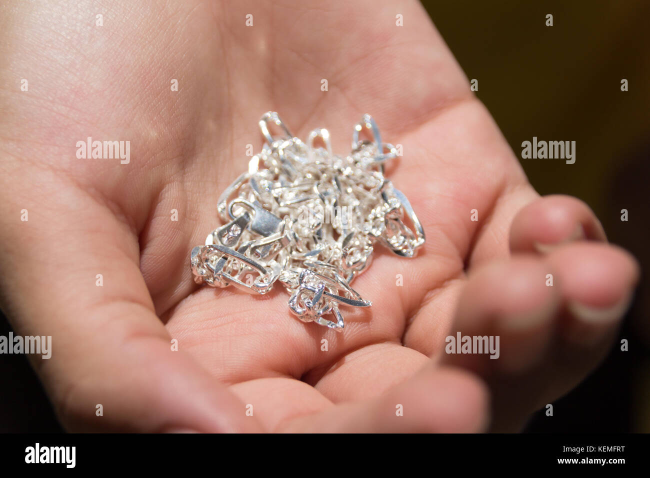 Photograph of a human hand with silver chain Stock Photo - Alamy