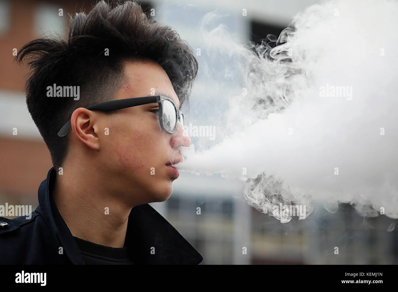 Asian young man smoking on the street Stock Photo - Alamy
