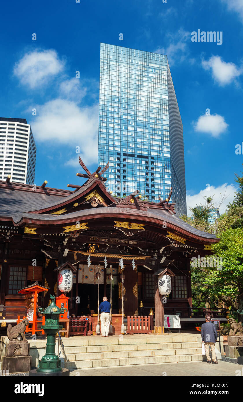 Tradition and Modernity in Japan. People pray in an old temple below ...