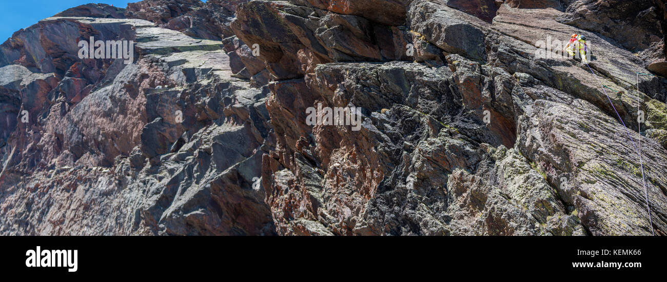From below panoramic view of man climbing high on mountain Stock Photo ...