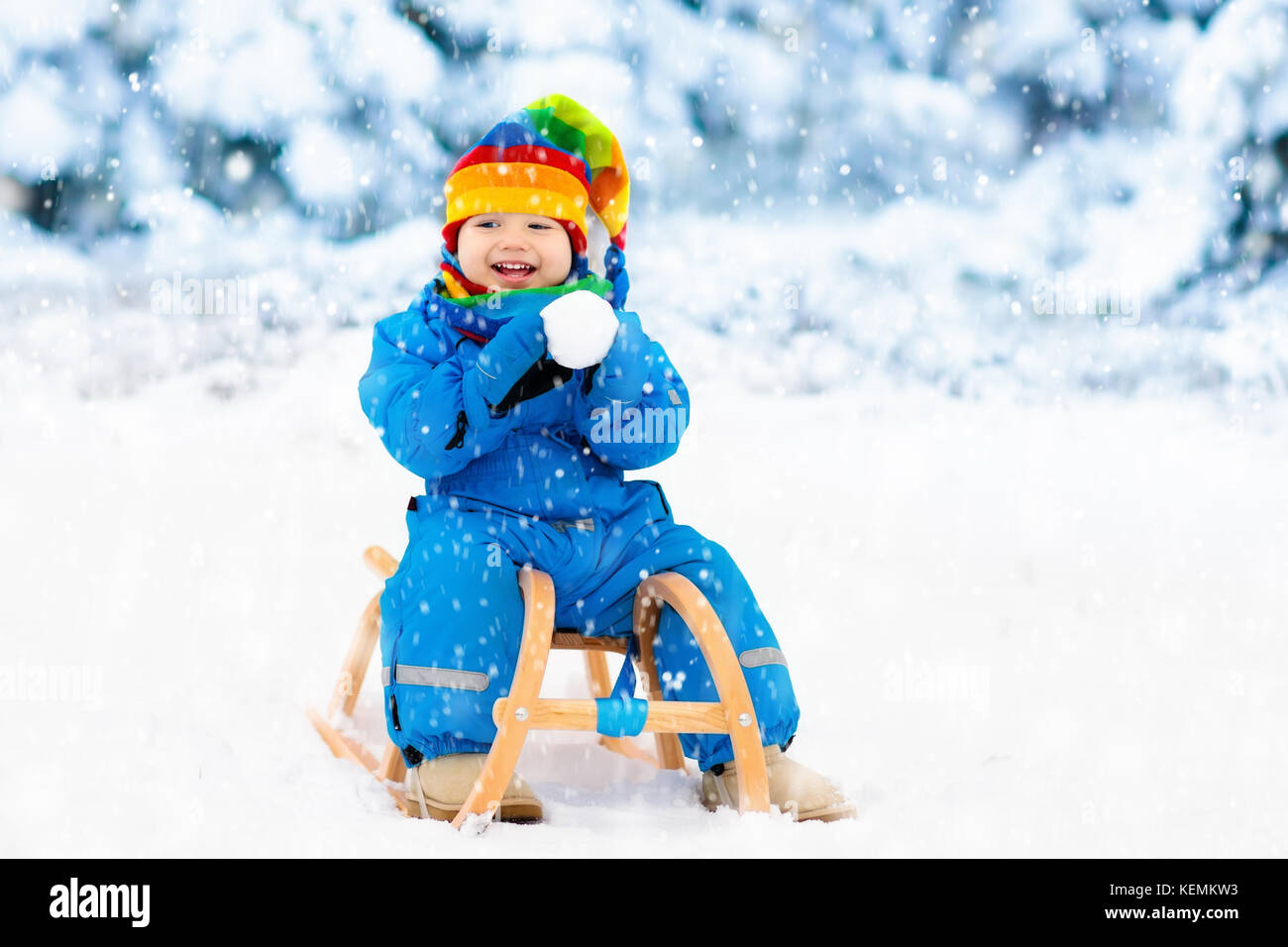 Little boy enjoying a sleigh ride. Child sledding. Toddler kid riding a ...