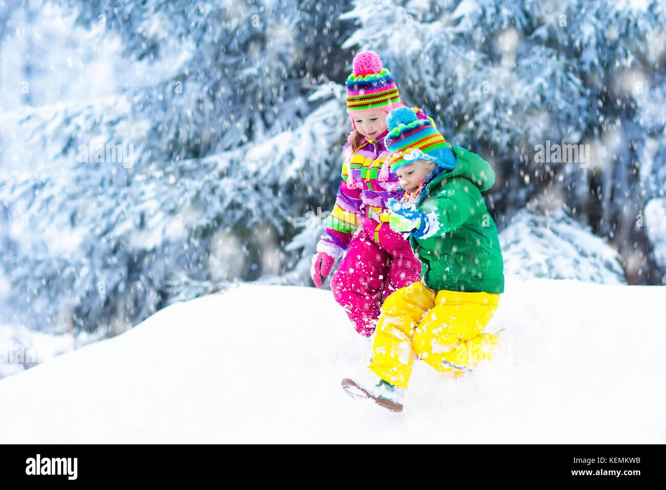 Kids playing in snow. Children play outdoors on snowy winter day. Boy ...