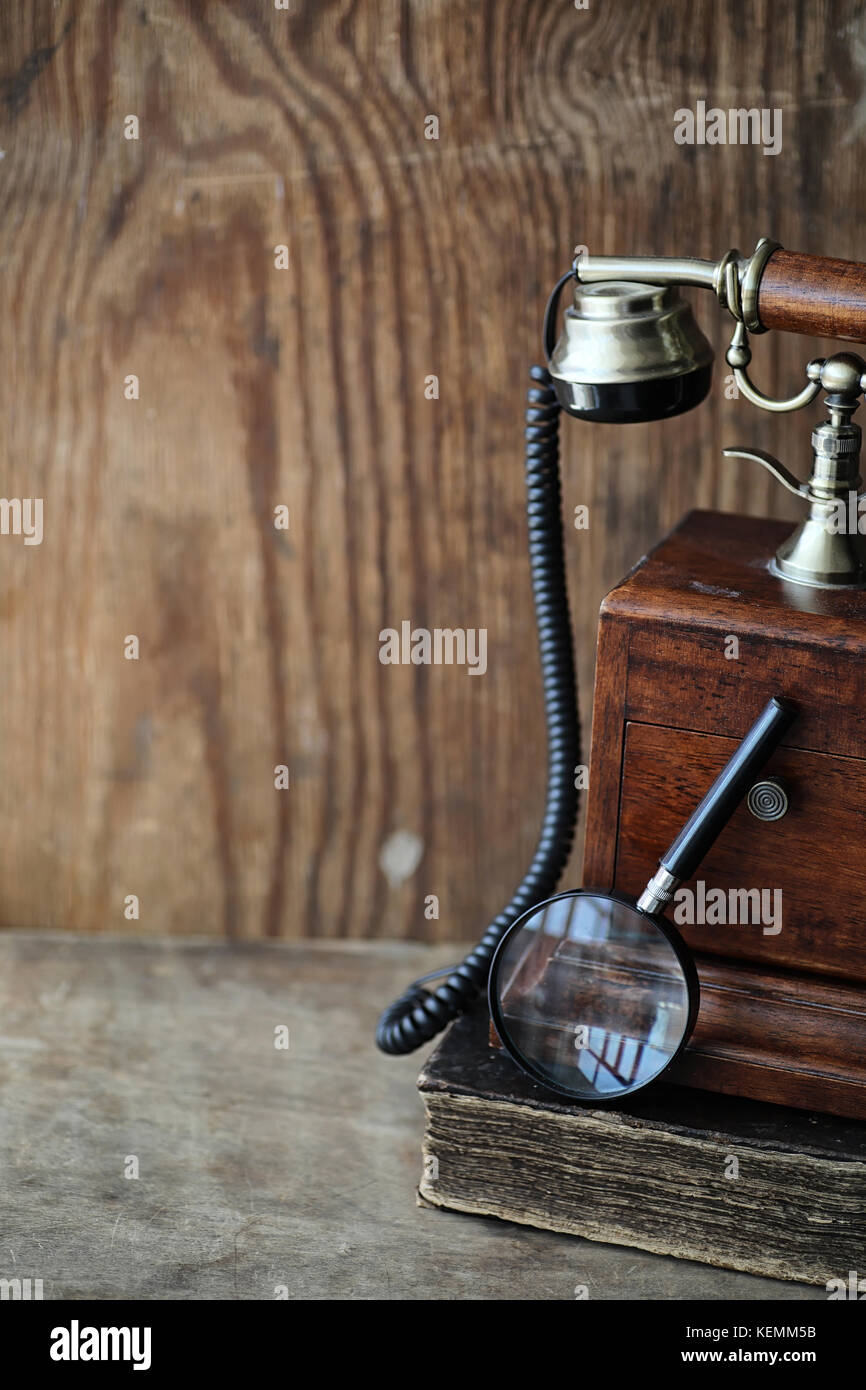 Old telephone and retro book on a wood Stock Photo - Alamy