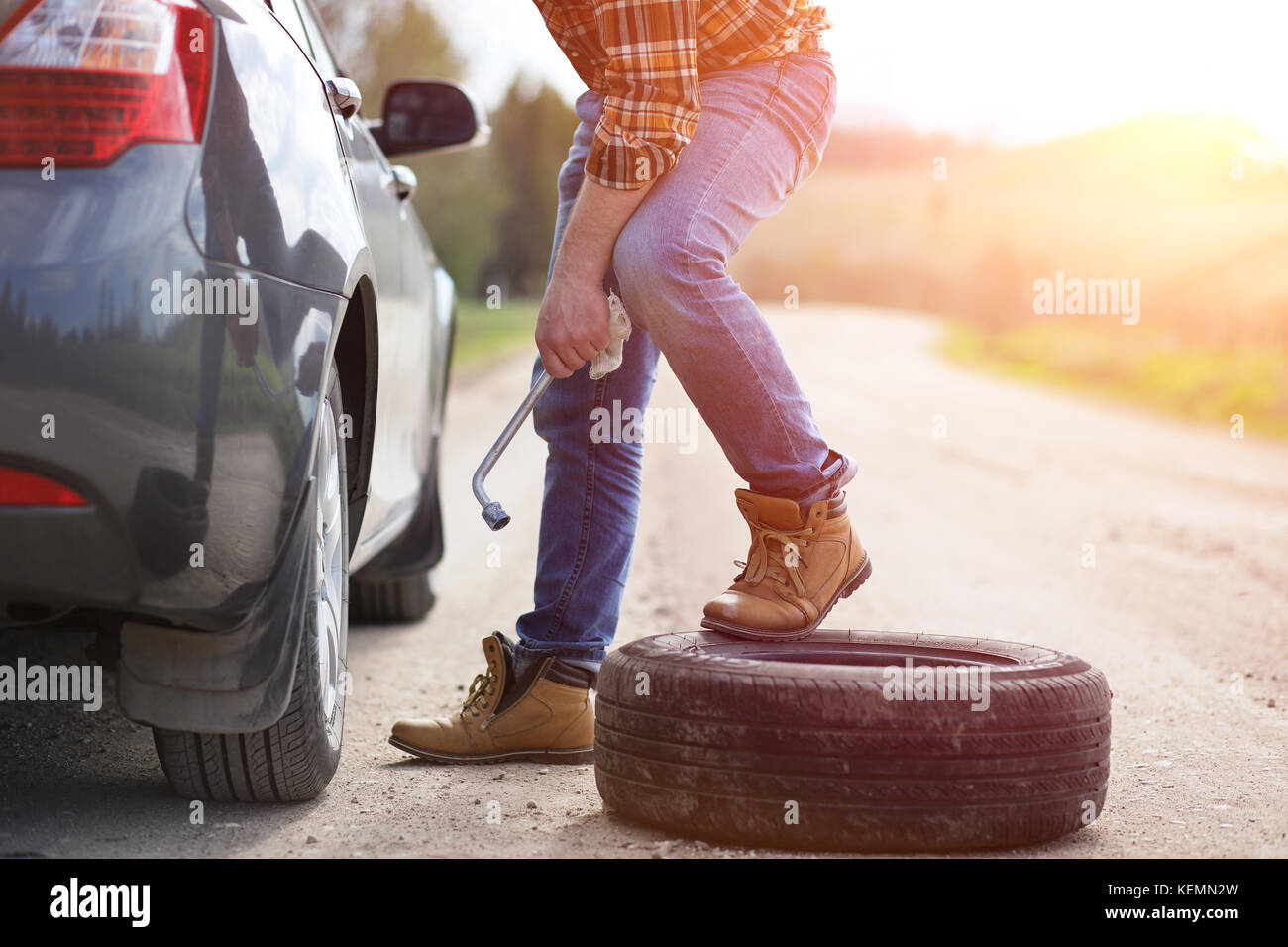 Man is sitting on the road by the car Stock Photo - Alamy